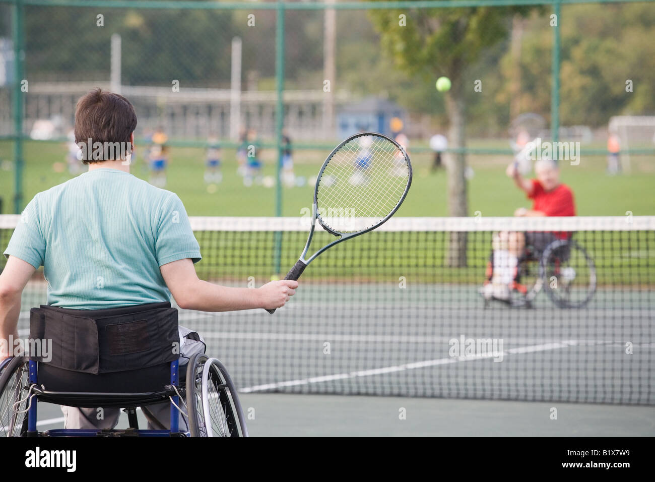 Two handicapped men sitting in wheelchair and playing tennis Stock ...