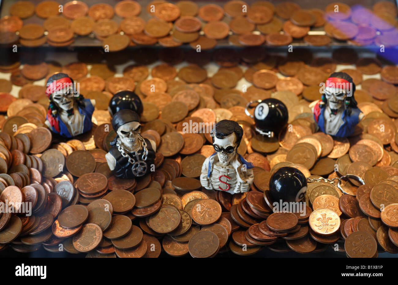 Punk pirate figurines as prizes in a penny falls at an amusement arcade ...