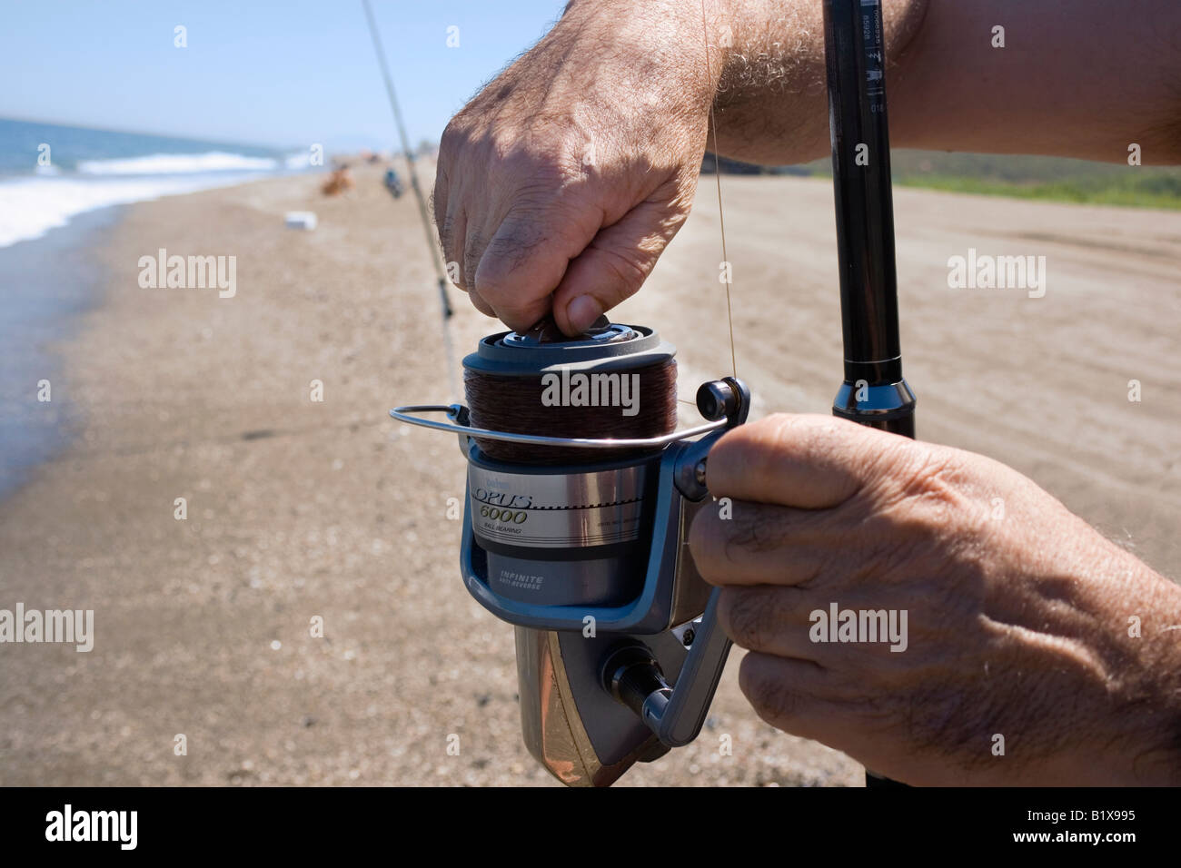 Mans hands holding fishing rod Stock Photo - Alamy