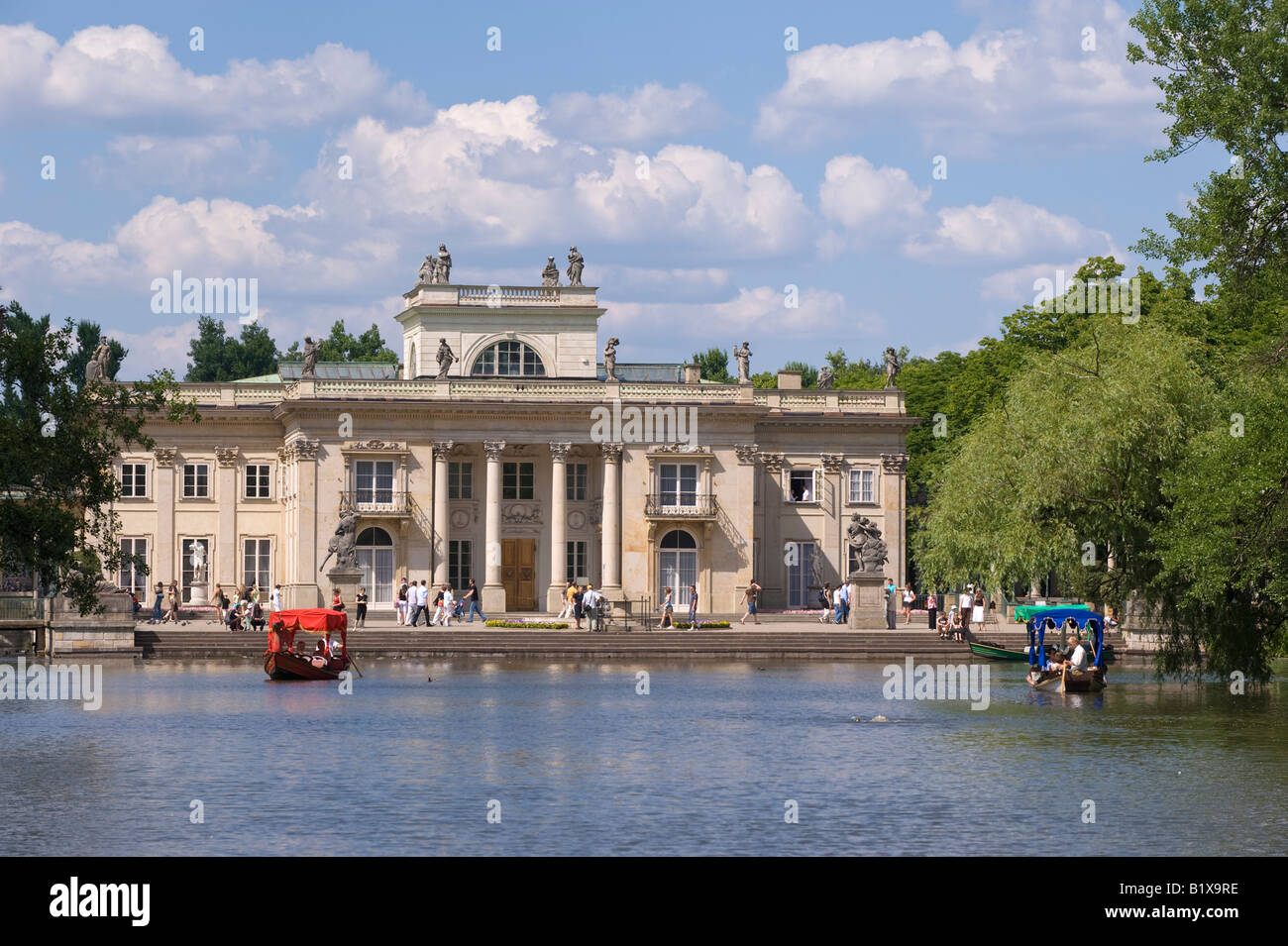 People relax in a gondola with Lazienkowski Palace in background ...