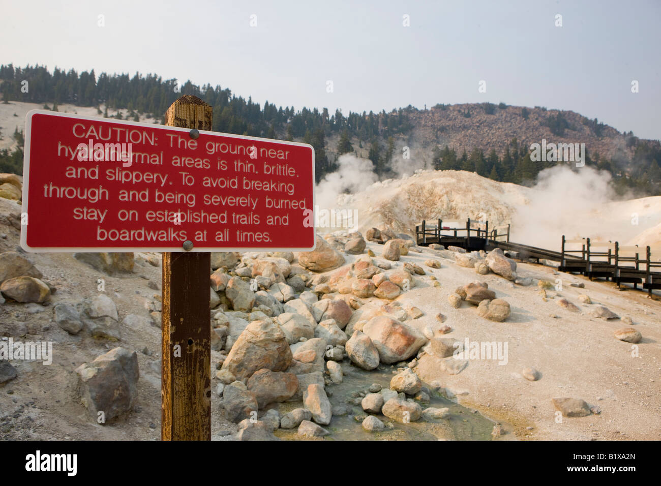 A red caution sign warns visitors to say on the boardwalk to avoid ...