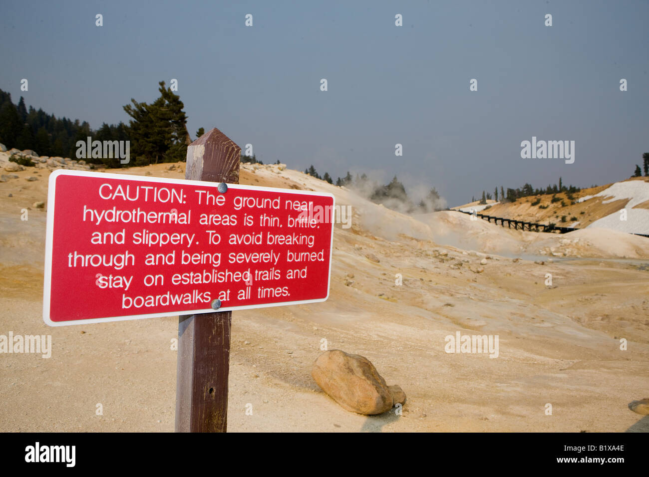 A red caution sign warns visitors to say on the boardwalk to avoid ...