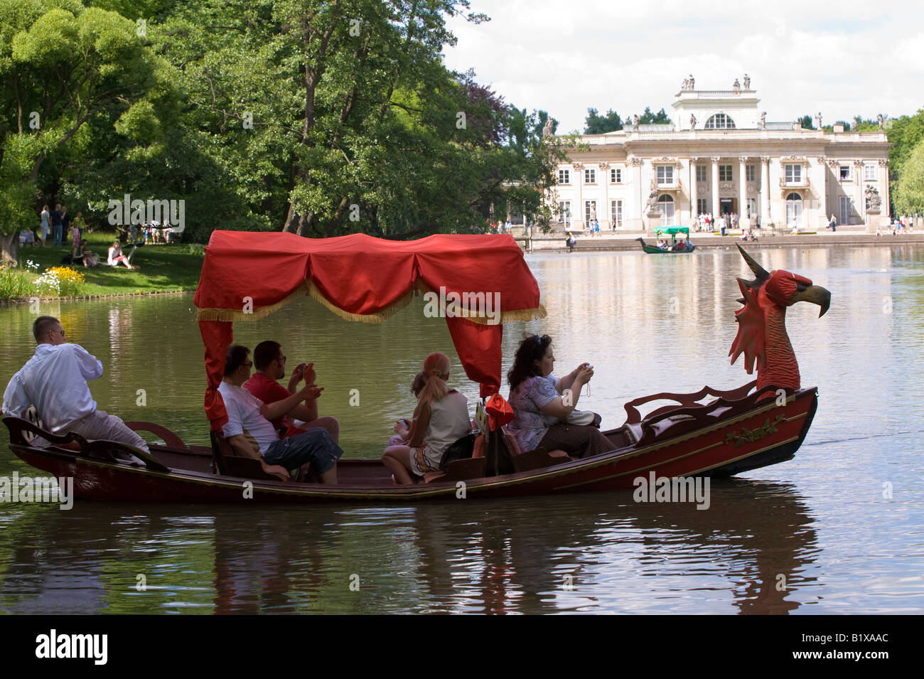 People relax in a gondola with Lazienkowski Palace in background ...