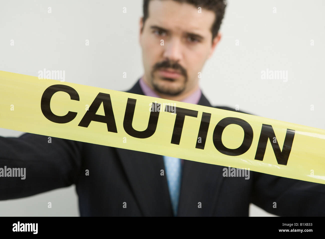 Portrait of a businessman holding a Caution tape Stock Photo - Alamy