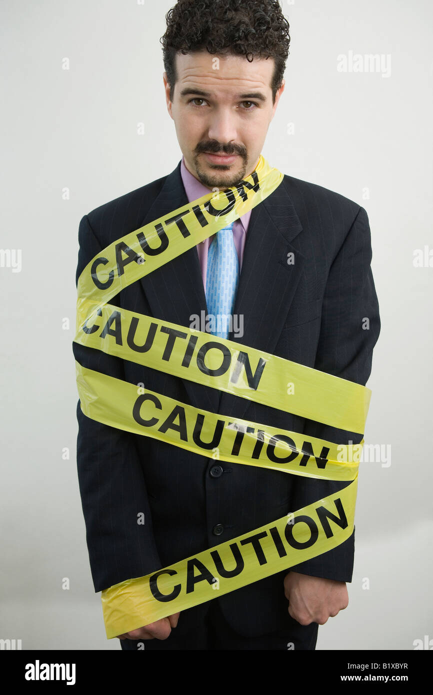 Portrait of a businessman wrapped in a Caution tape Stock Photo - Alamy