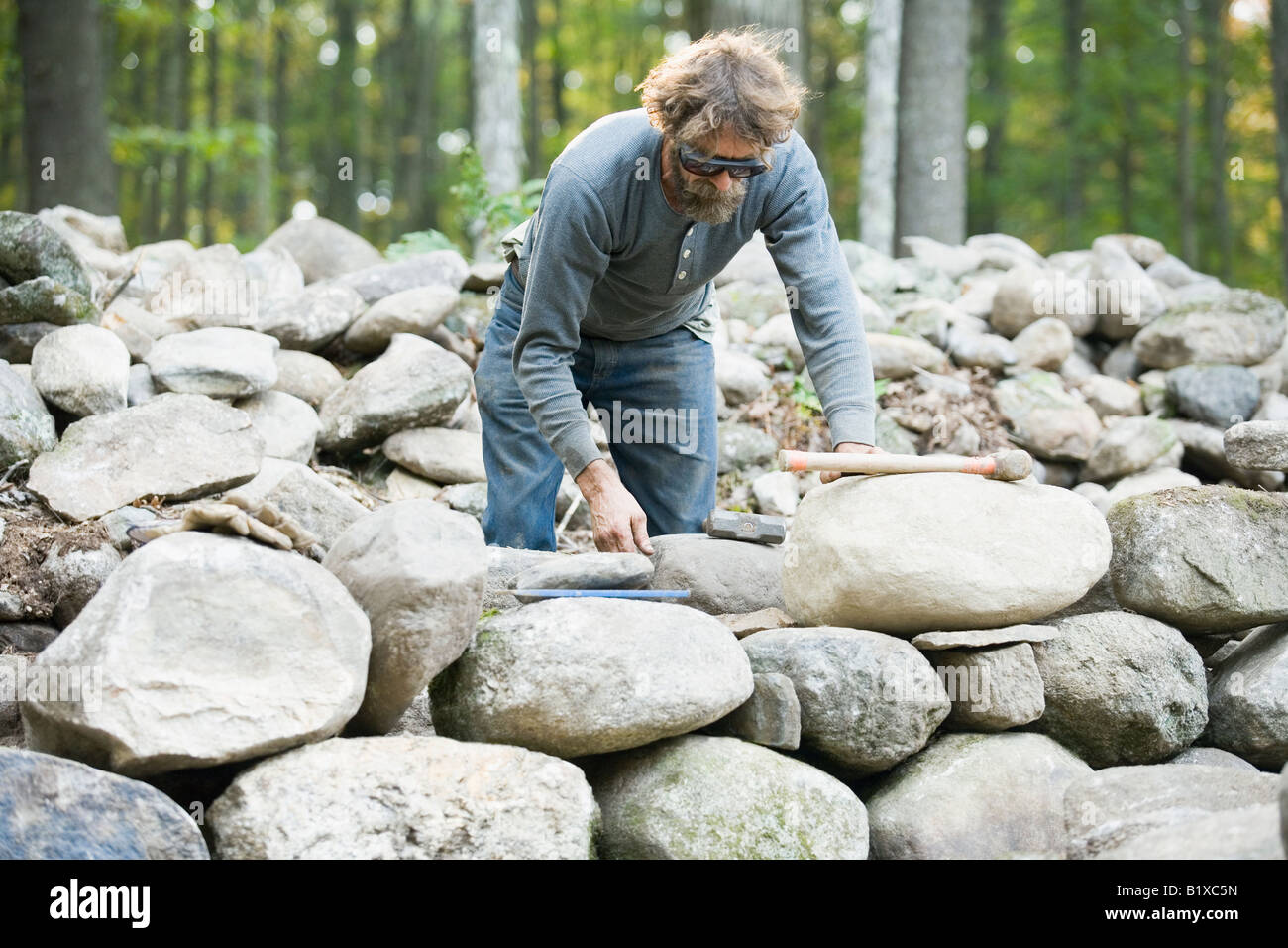 Mature man building stone fence Stock Photo - Alamy