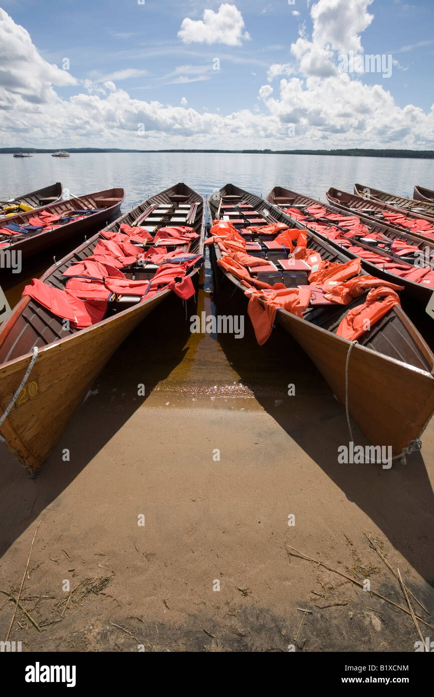 multi-seat wooden row-boats on shore Stock Photo - Alamy