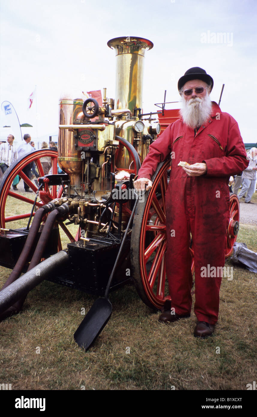 A Traditional Engineer Standing Next To A Vintage Fire Engine At The ...