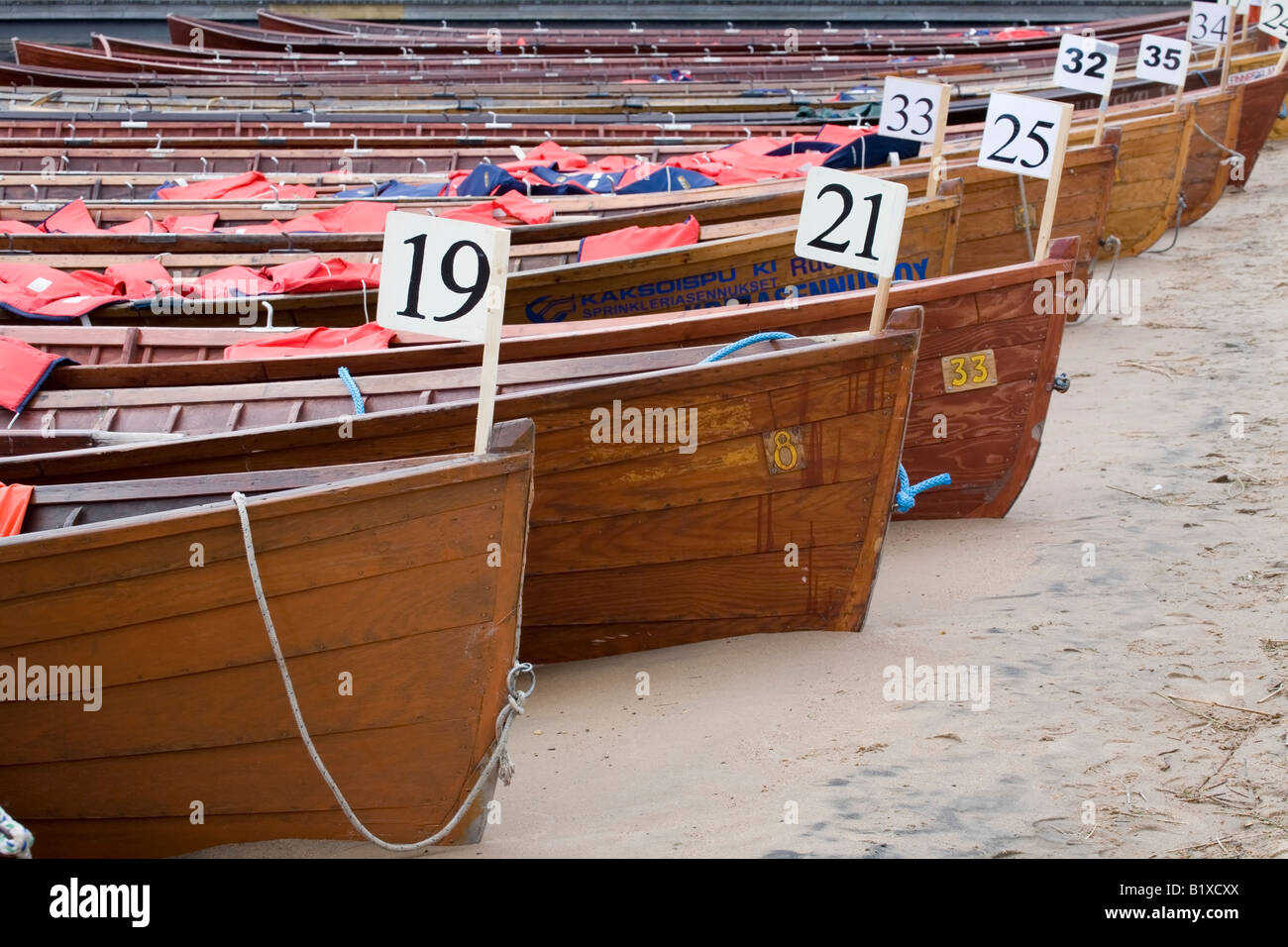 multi-seat wooden row-boats on shore Stock Photo - Alamy