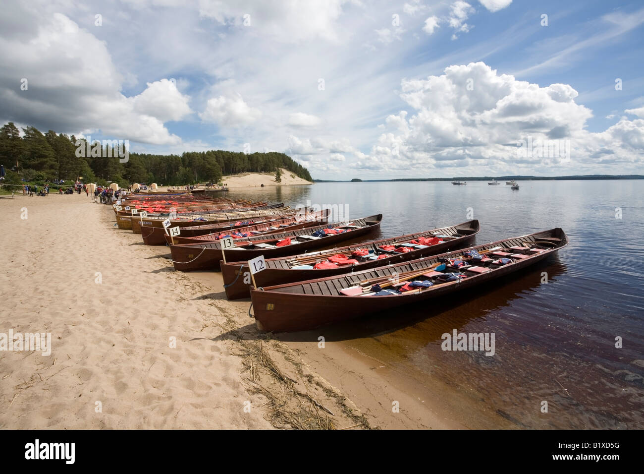 multi-seat wooden row-boats on shore Stock Photo - Alamy