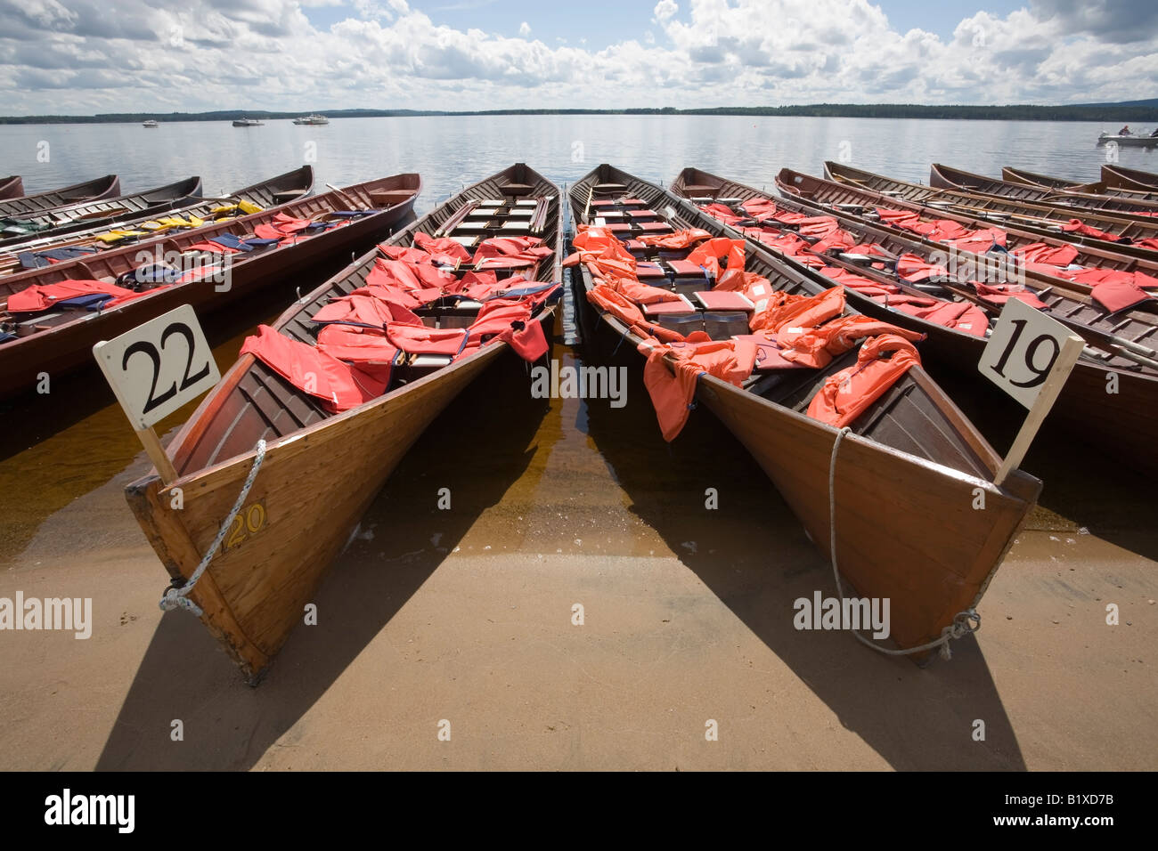 multi-seat wooden row-boats on shore Stock Photo - Alamy