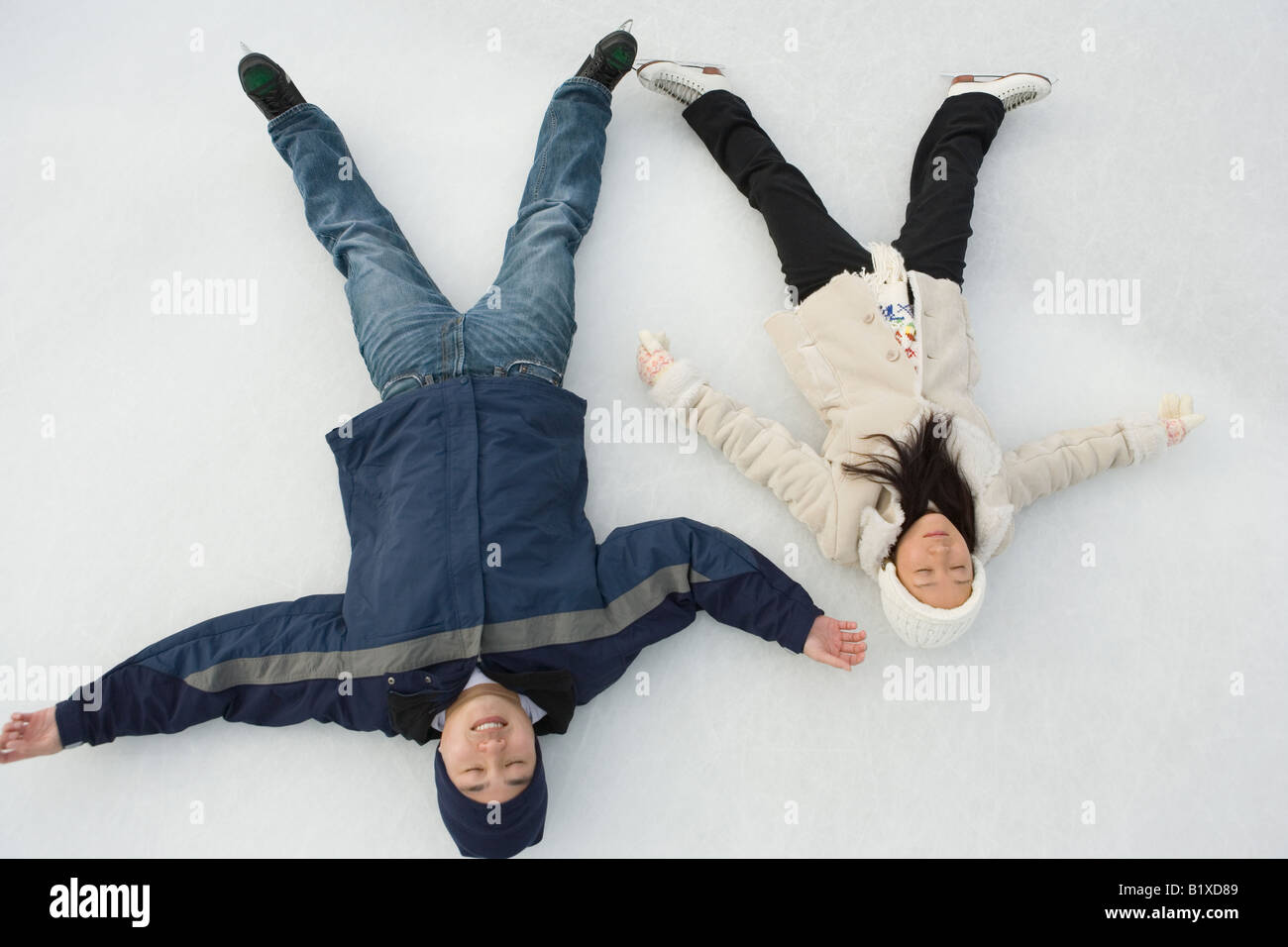 Young couple lying on an ice rink Stock Photo - Alamy