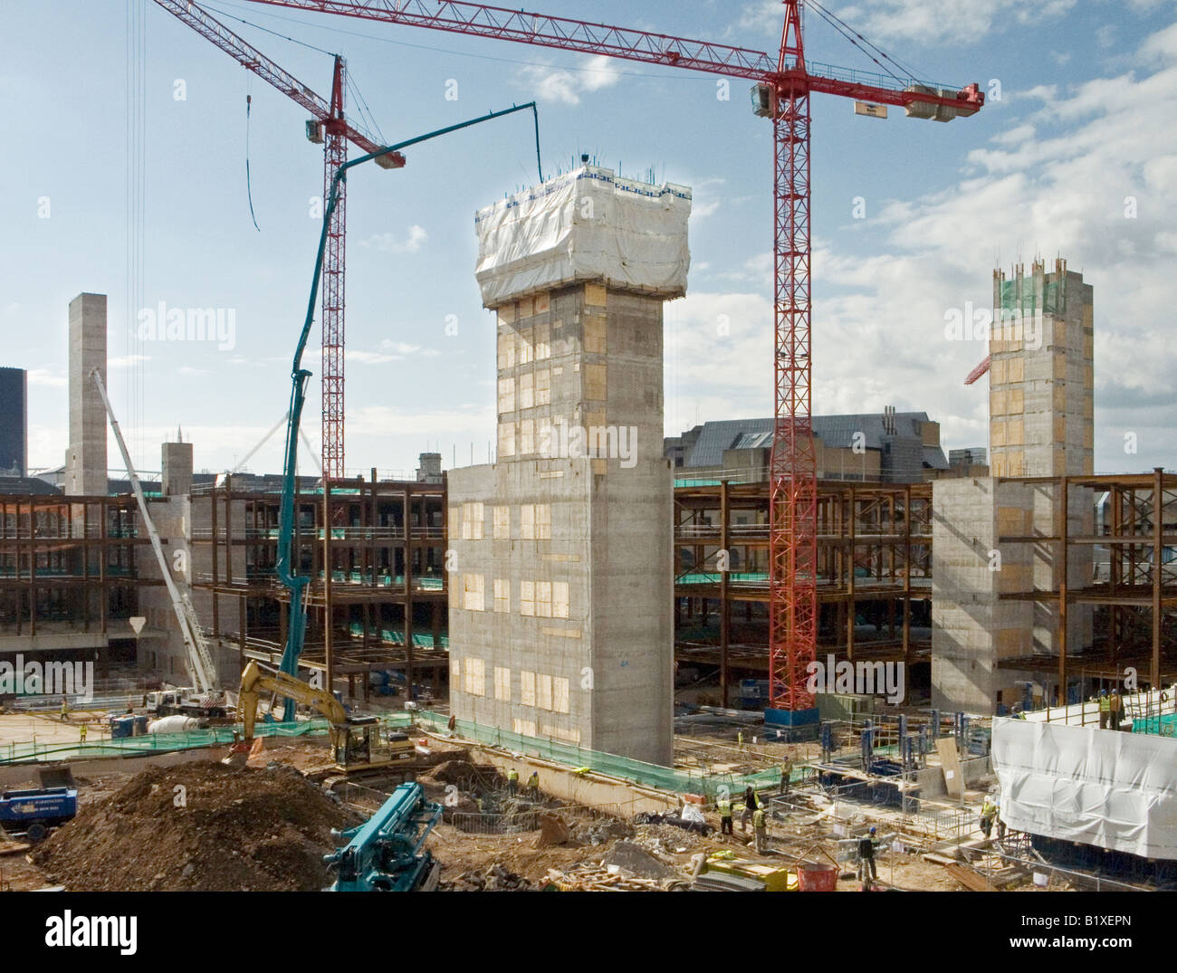 concrete pumping at a city centre construction site with red tower ...