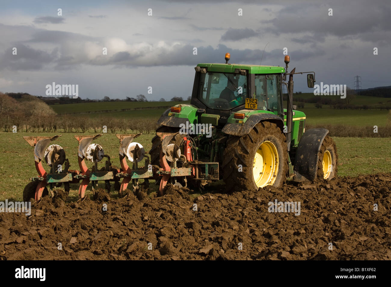 Tractor ploughing field Stock Photo - Alamy