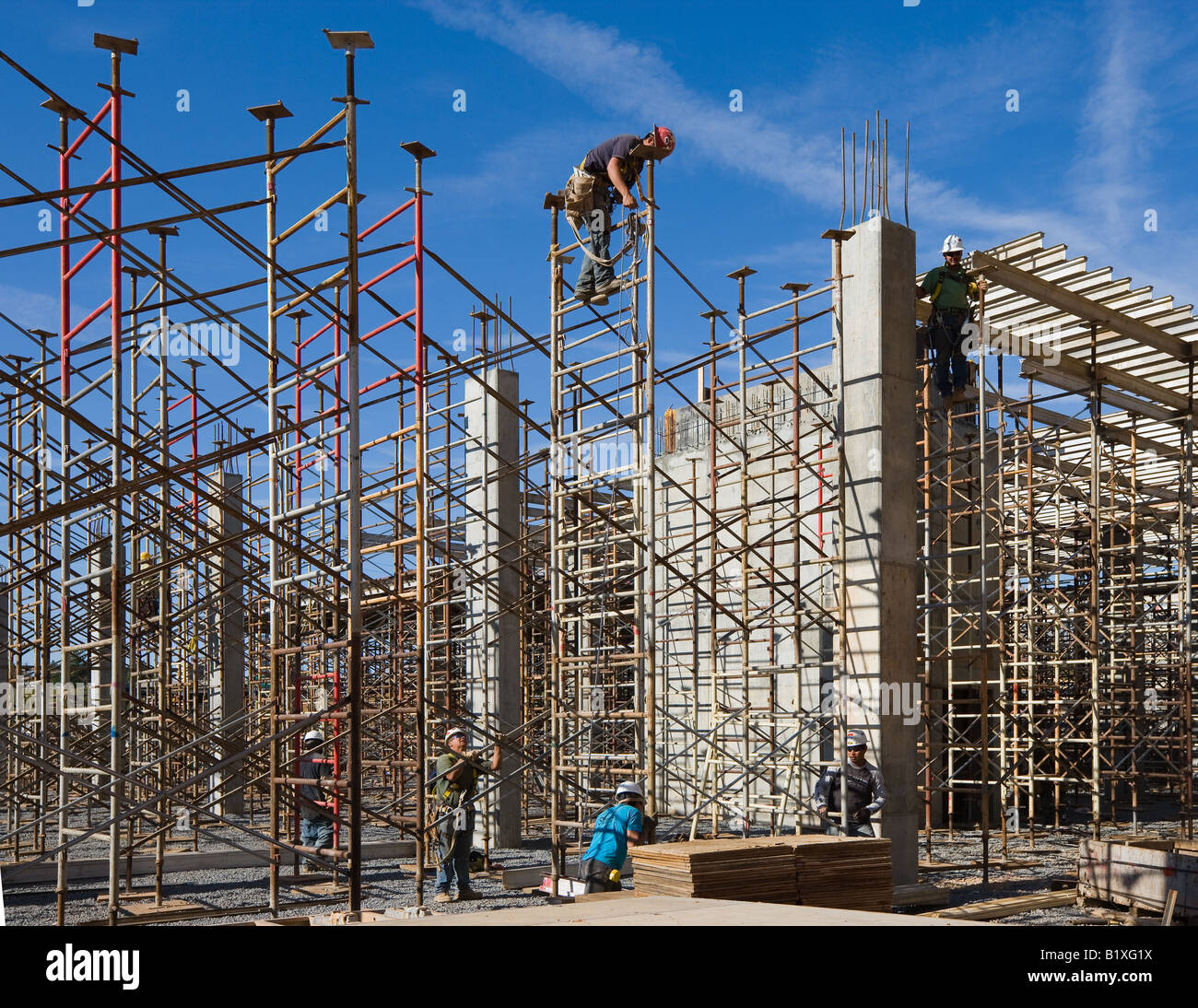 Construction workers standing atop concrete forms waiting for the pour ...