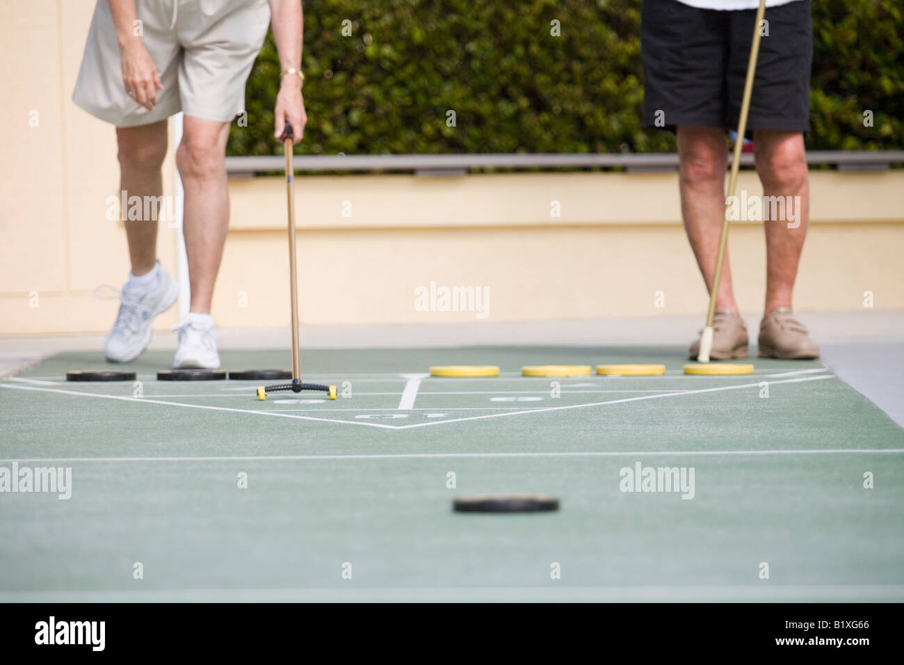 Low section view of a two senior men playing shuffleboard Stock Photo ...