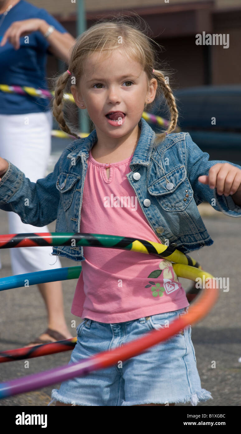 smiling 4 year old blond girl hula hooping with two hoops at once ...