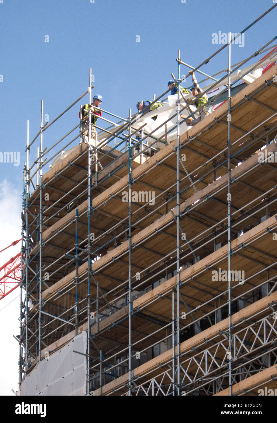 workmen ercting scaffold on a building under construction Stock Photo ...