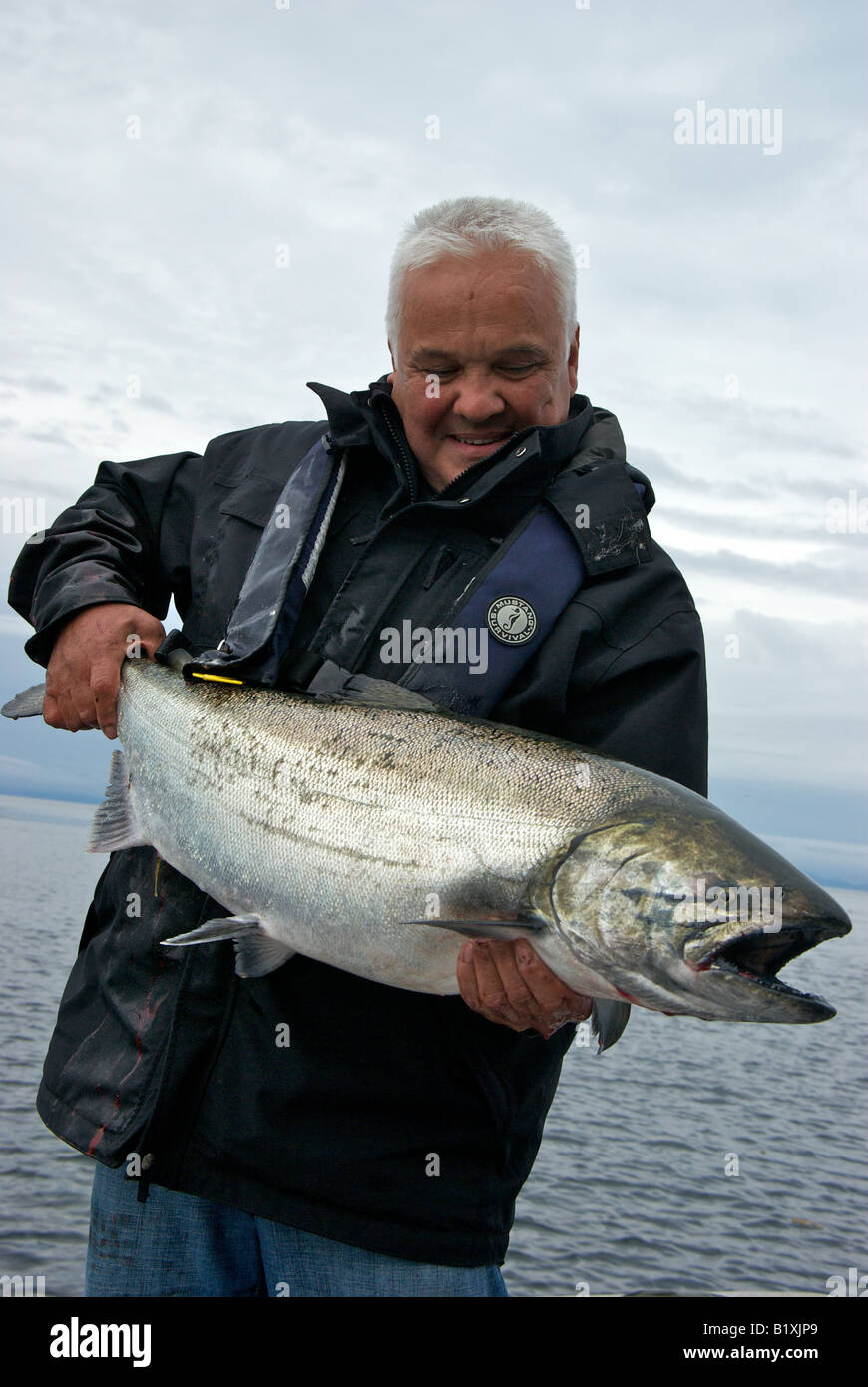 Male angler holding a big trophy troll caught chinook salmon fish from ...