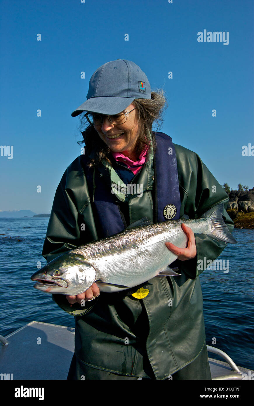 Woman holding a big BC coho salmon fish at Gnarled Islands in northern ...