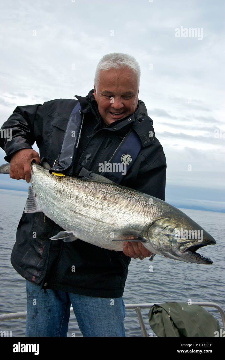 Male angler holding up a big trophy northern British Columbia chinook ...