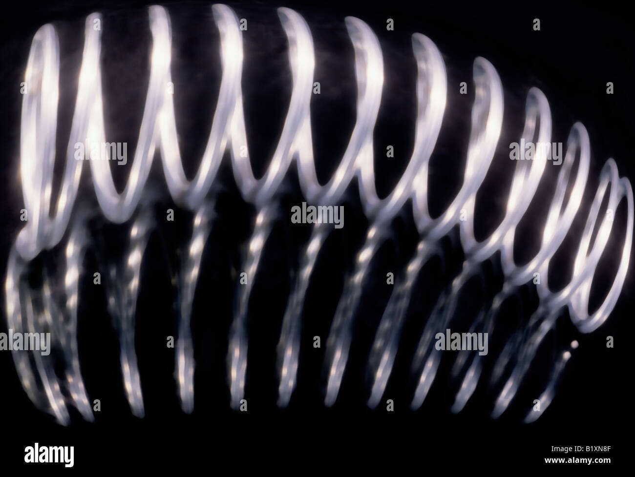 Metal spring isolated coiled and expanding on a black background Stock ...