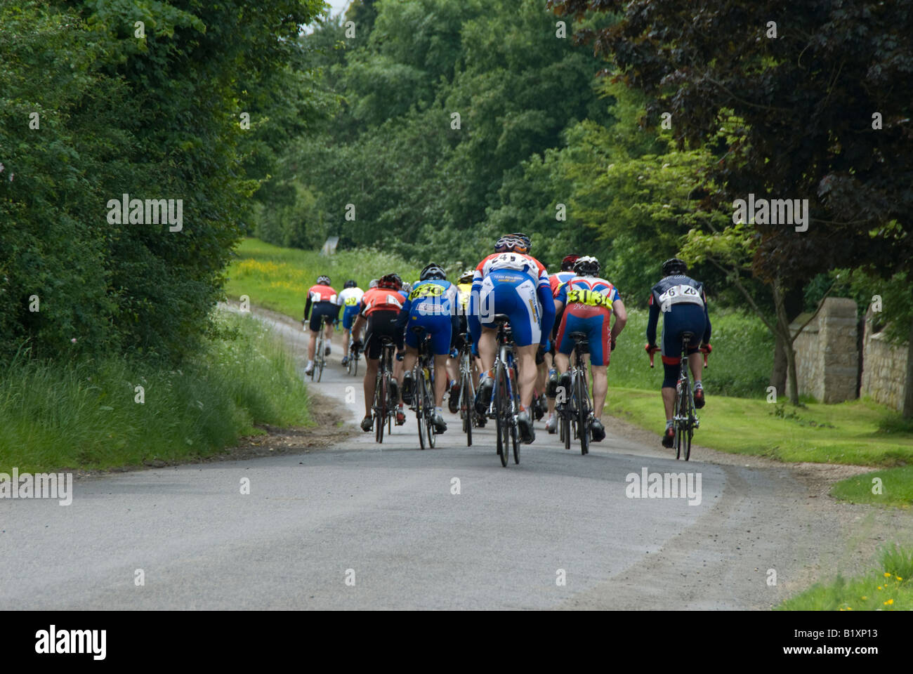A group of racing cyclists taking part in an event on country roads in ...