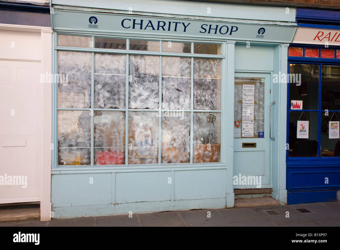 Charity shop closed down with whitewashed windows Stock Photo - Alamy