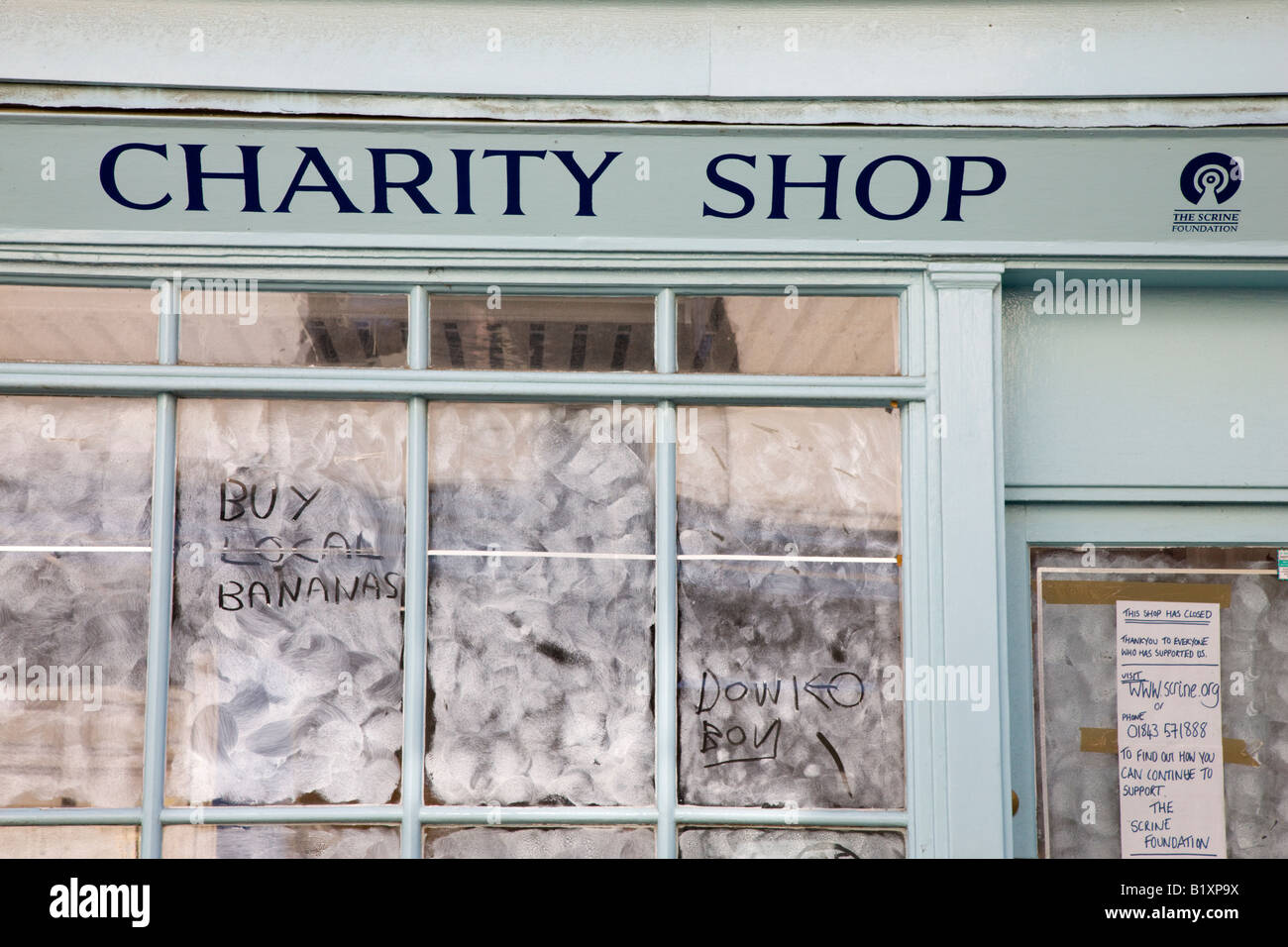 Charity shop closed down with whitewashed windows Stock Photo - Alamy