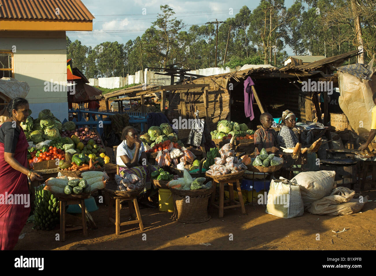 African street traders on market stall selling fruit and vegetables ...