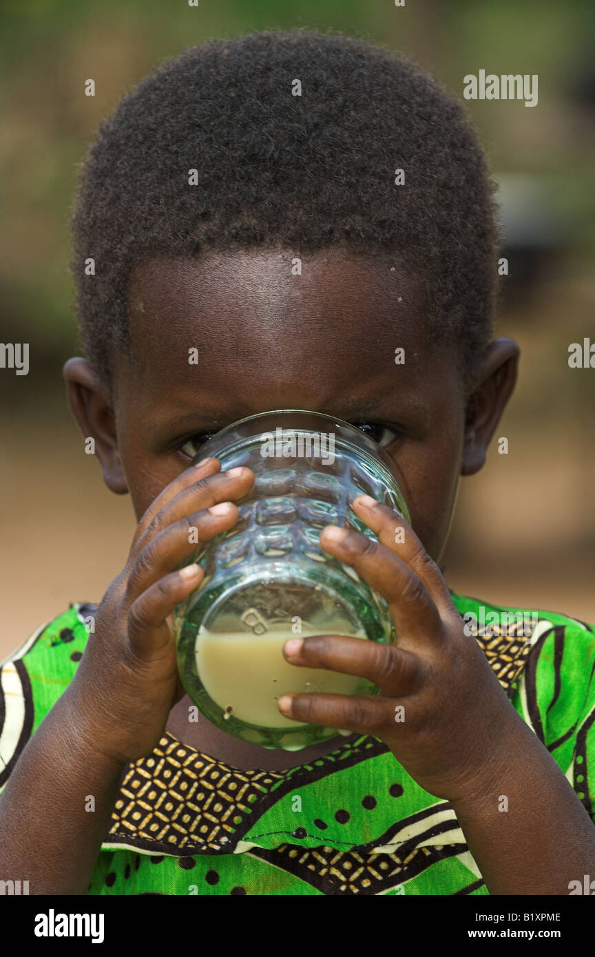 Young African drinking goats milk from glass eastern Uganda Africa ...