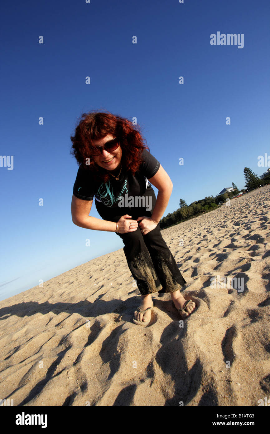 A VIVACIOUS RED HAIRED WOMAN LOOKING INTO THE CAMERA BLUE SKY ...