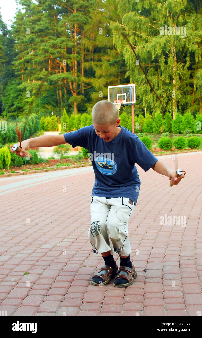 Young boy jumping rope near warehouse Stock Photo - Alamy