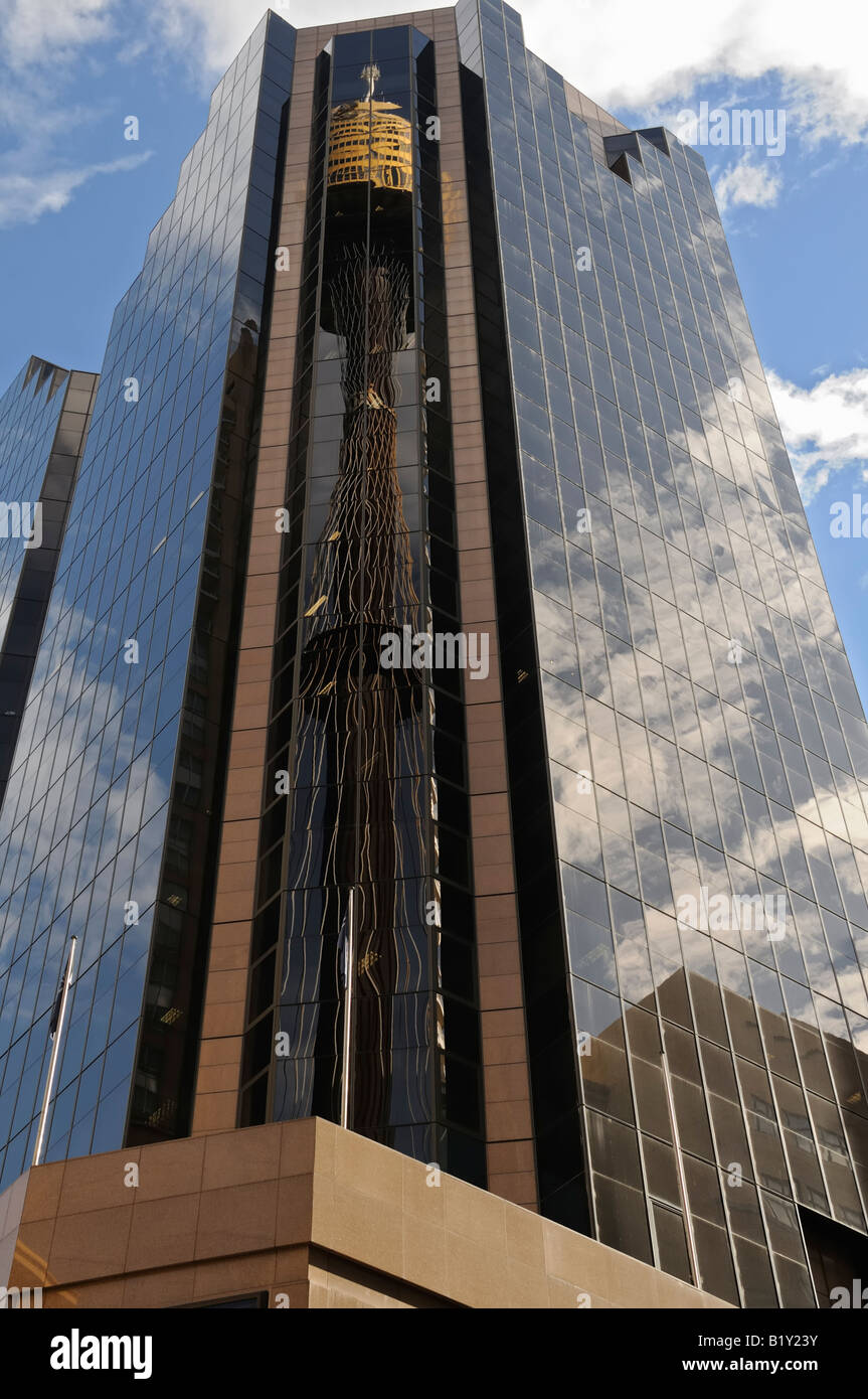 A mirrored glass tower reflecting the partly cloudy sky and the Sky ...