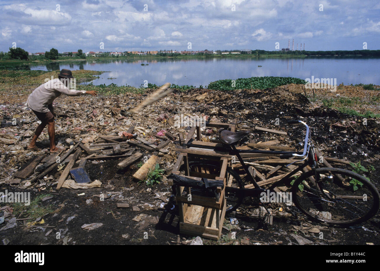 Collecting wood to make a meagre living out of an open rubbish tip in ...