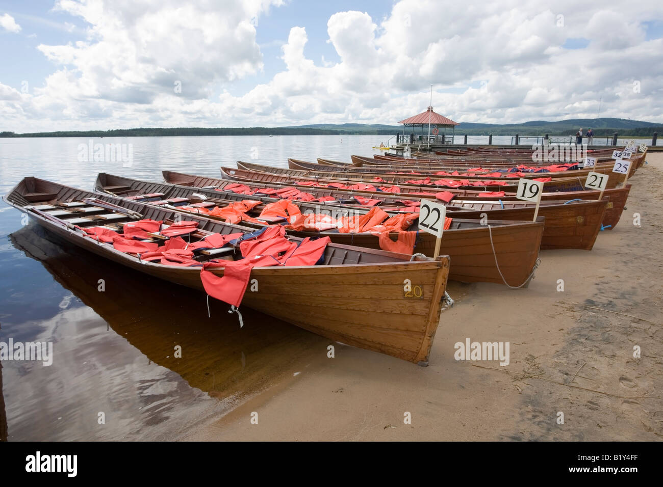 multi-seat wooden row-boats on shore Stock Photo - Alamy
