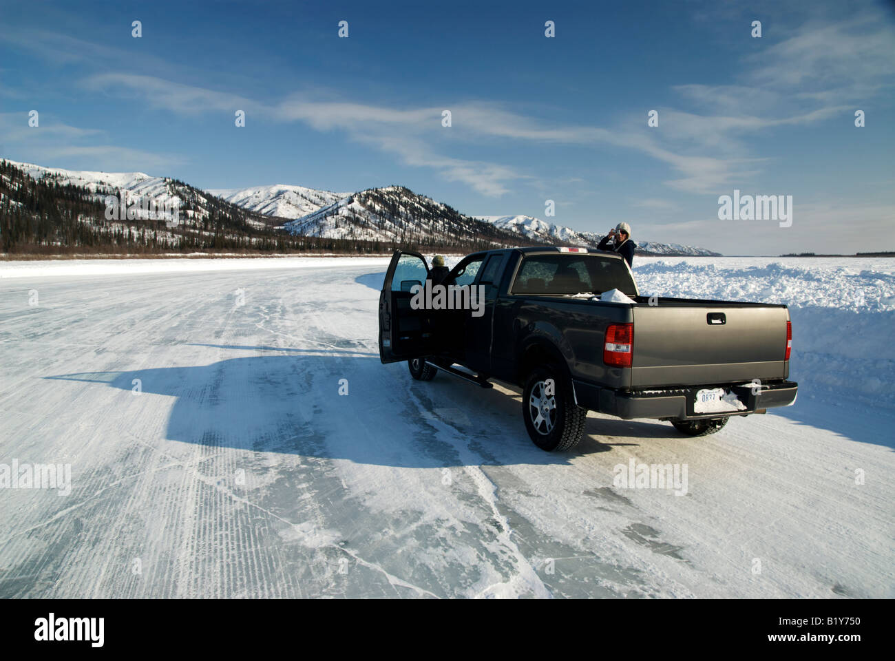 Two people in their car driving the ice highway to Tuktoyaktuk ...