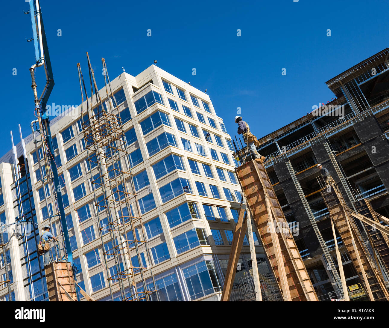 Construction workers standing atop concrete forms waiting for the pour ...