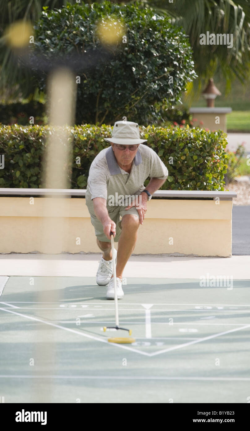 Senior man playing shuffleboard Stock Photo - Alamy