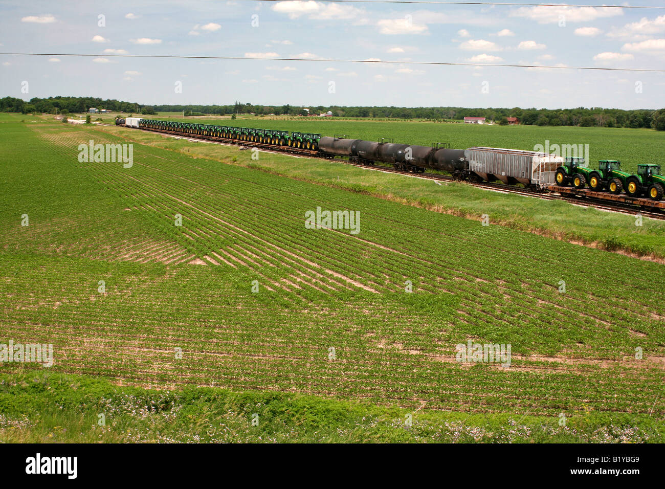 Train with farm tractors being delivered passes soybean field Stock ...