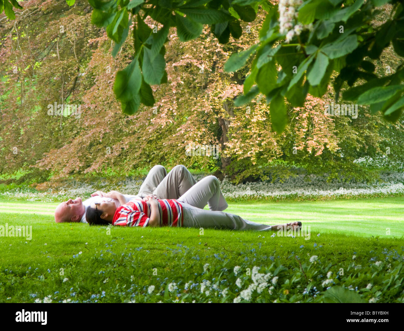 2 people relaxing on a lawn Stock Photo - Alamy