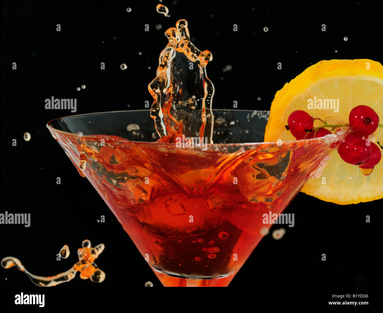 red liquid in a cocktail glass splashing Stock Photo - Alamy