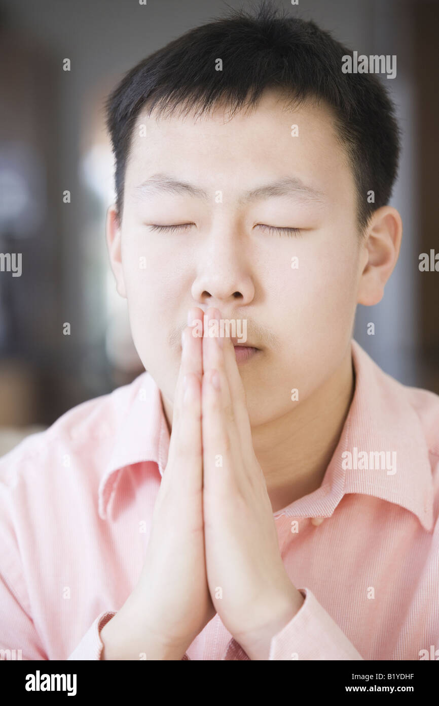 Close-up of a teenage boy praying Stock Photo - Alamy