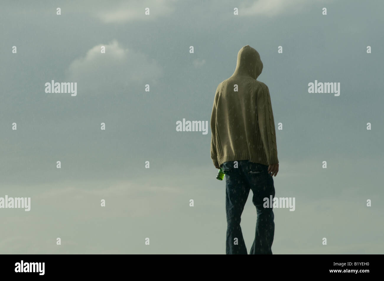 rear view of young man wearing hooded woollen cardigan walking in the ...
