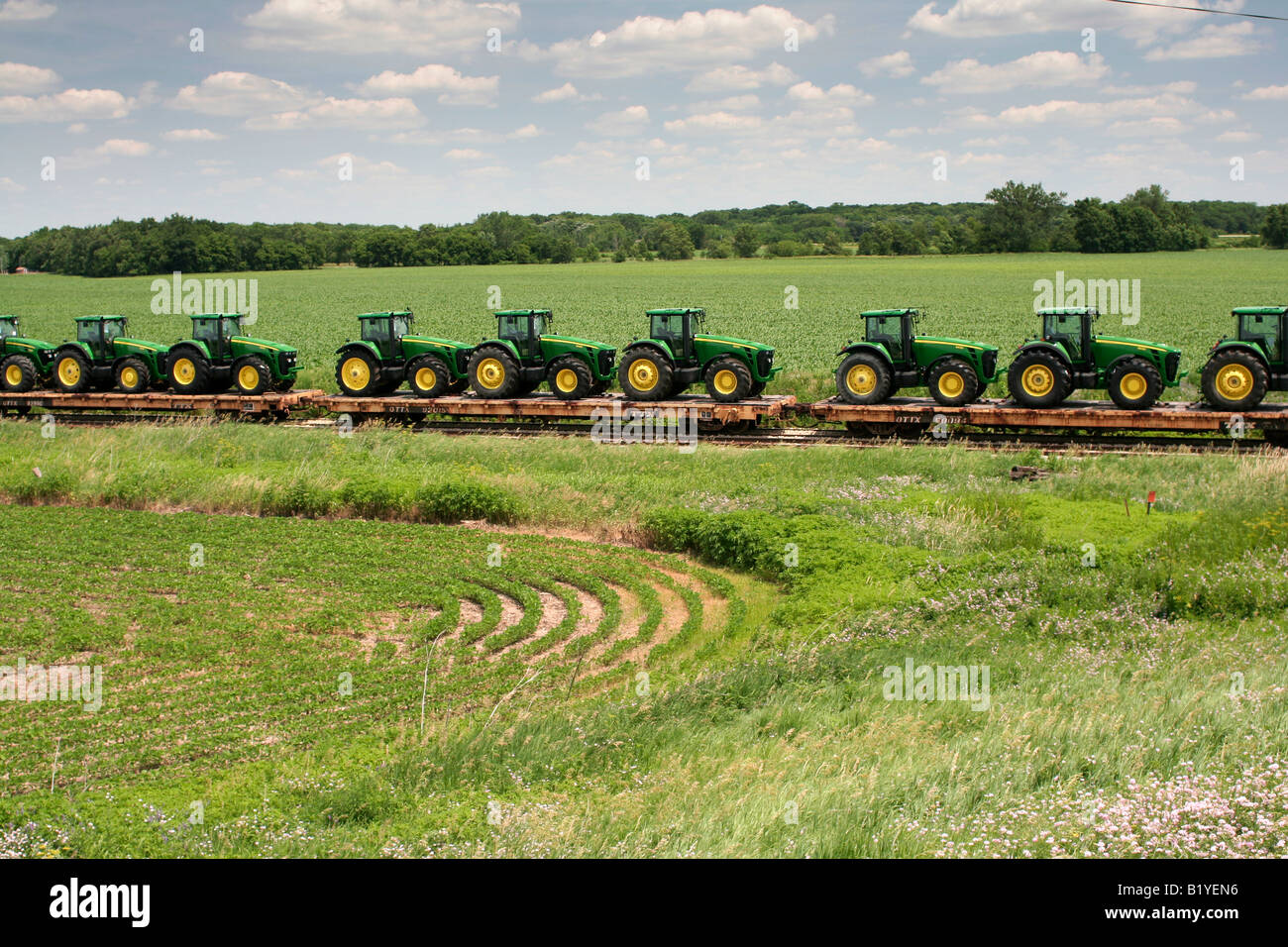 Factory fresh farm tractors on train Stock Photo - Alamy