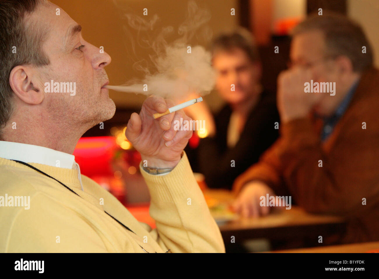 a man smoking a cigarette in a restaurant Stock Photo - Alamy