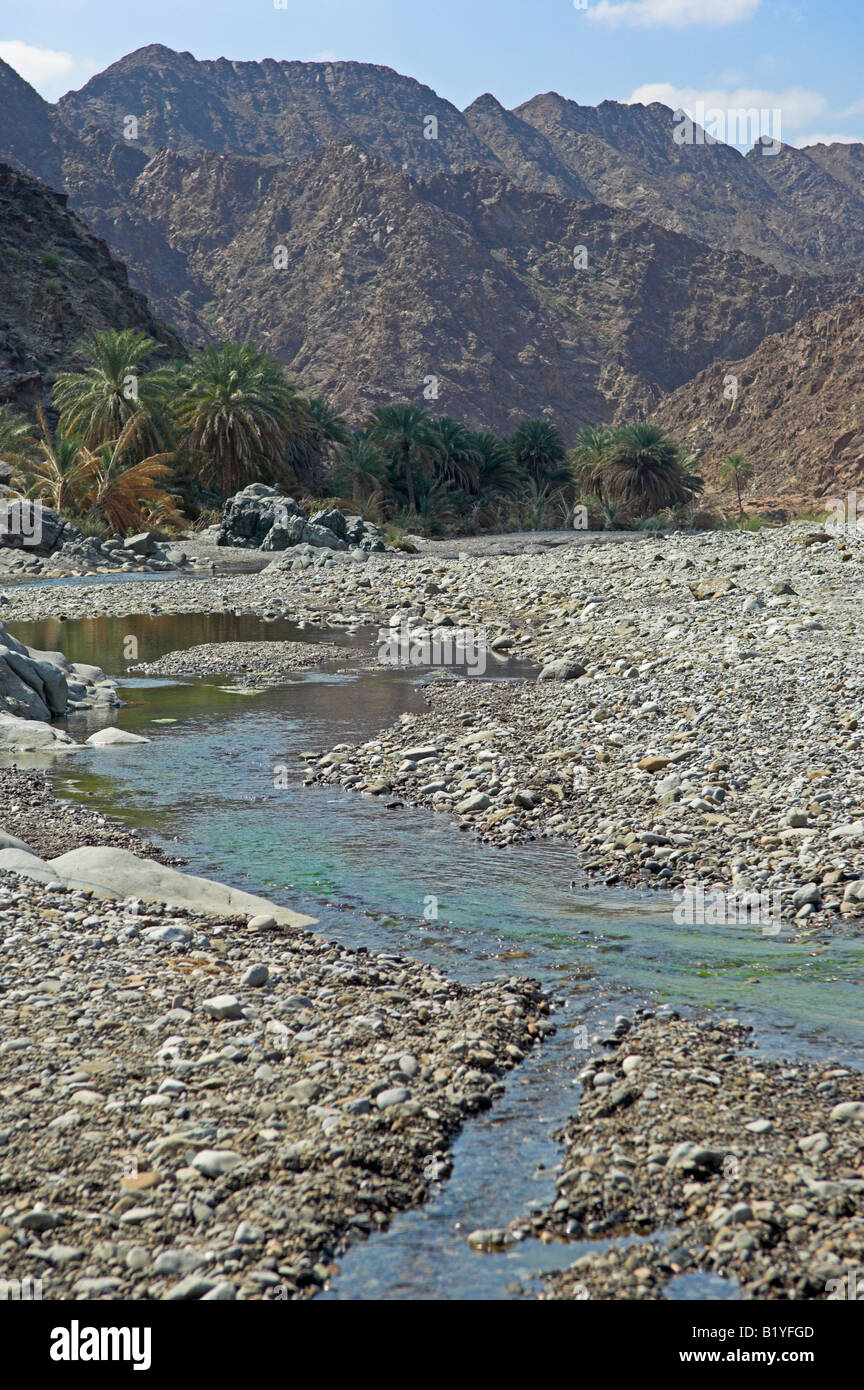 Wadi Al Abyad with spring water and mountains in Oman Stock Photo - Alamy