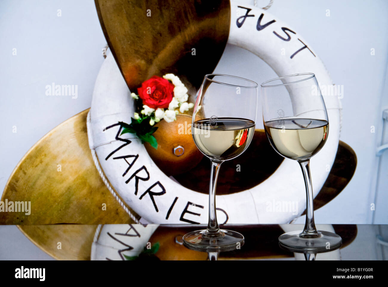 Two wine glasses on glass table lean towards each other with life belt ...