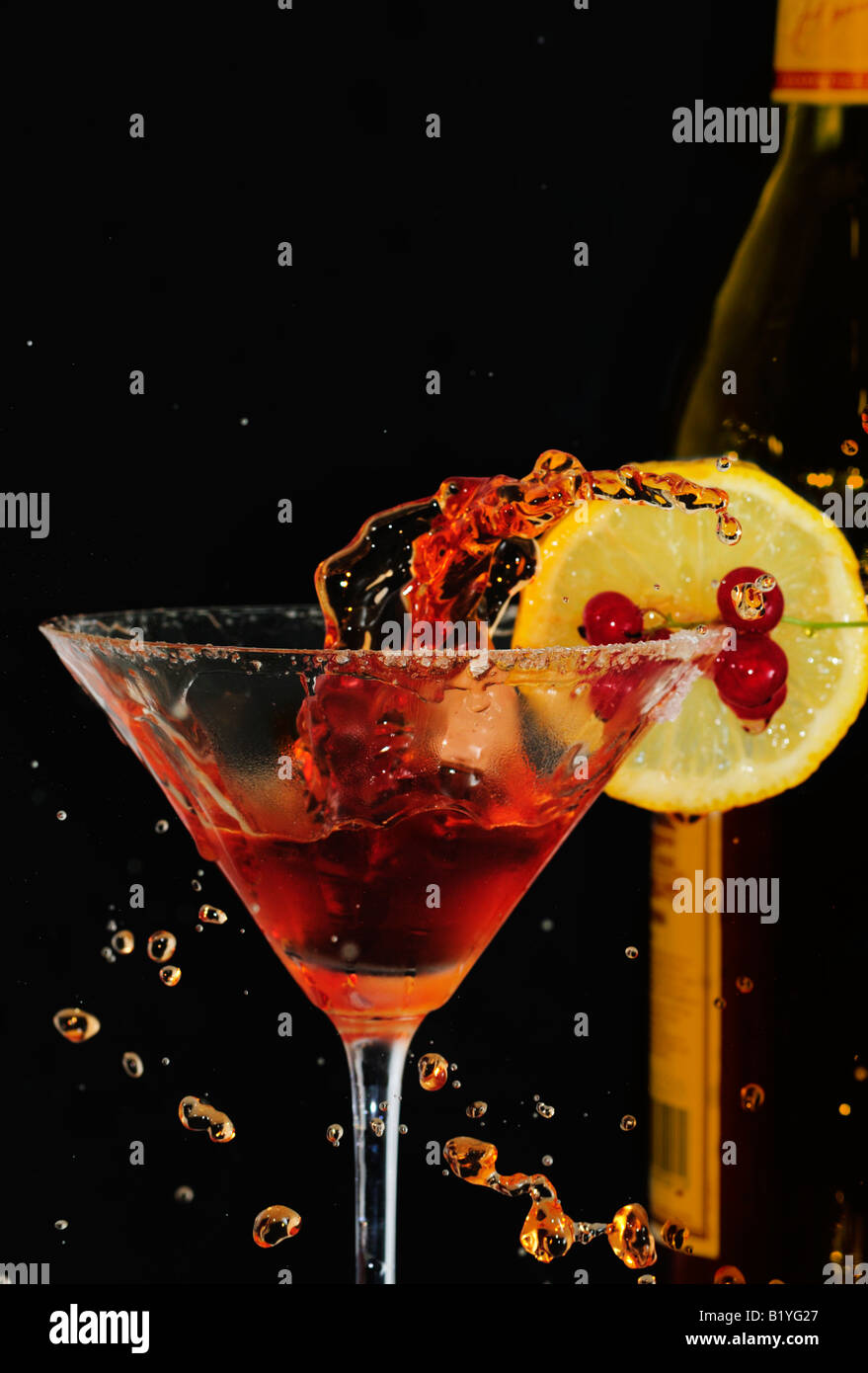splashing liquid in cocktail glas with bottle Stock Photo - Alamy