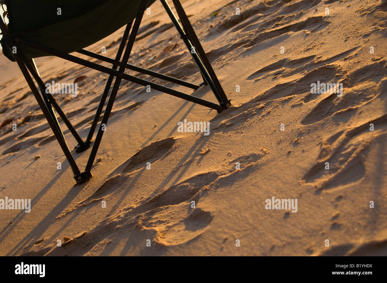 Folding chair on beach, sand and shadow Stock Photo - Alamy
